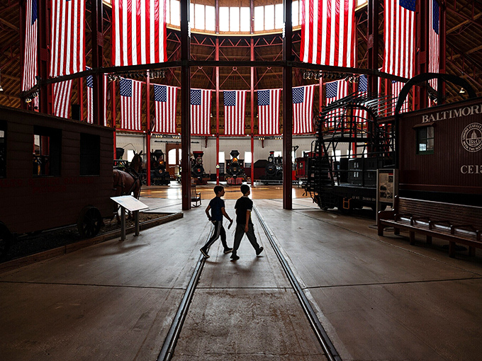 Inside the B&O Railroad Museum's magnificent roundhouse, American flags hang like patriotic bunting above iron horses that once thundered across a growing nation.