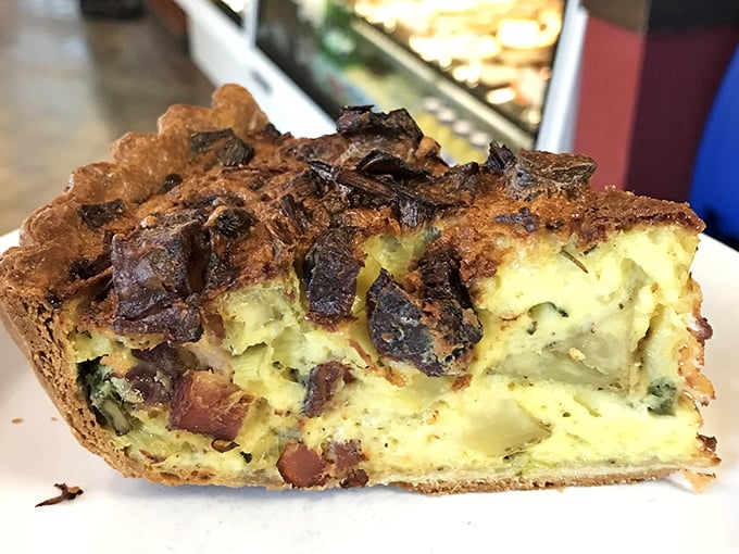 A slice of quiche that's having a better hair day than most of us. The custard-to-filling ratio here is what mathematicians call "the golden mean of deliciousness."