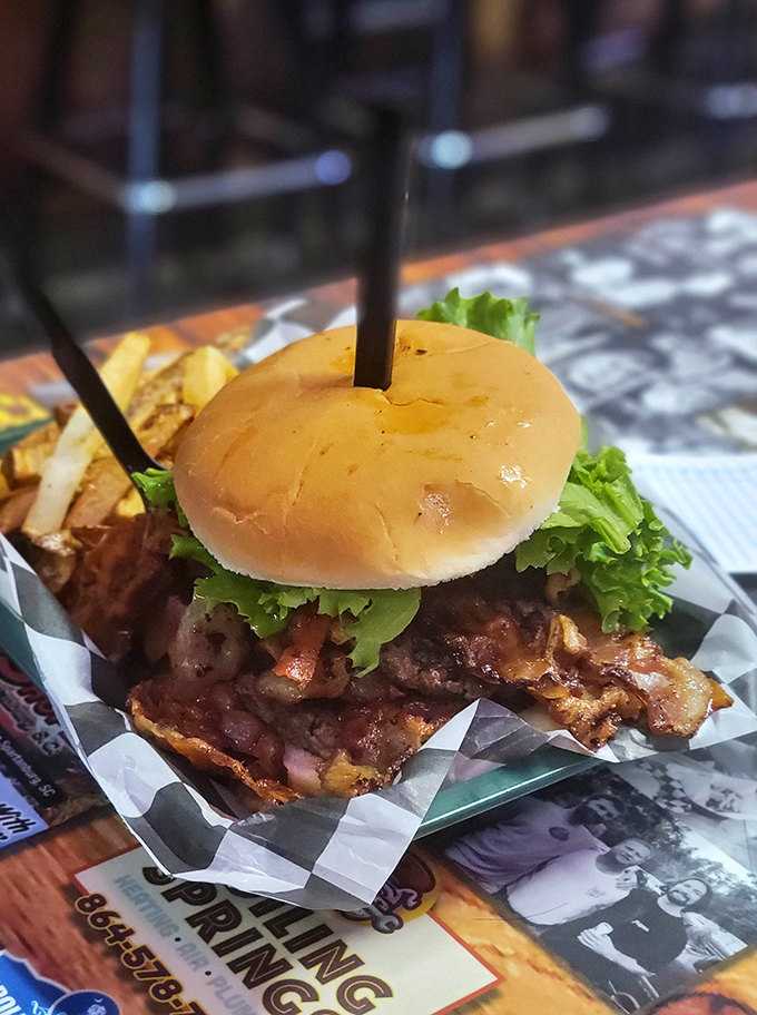 When bacon meets burger on a checkerboard throne, structural engineering becomes necessary just to take that first magnificent bite of glory.