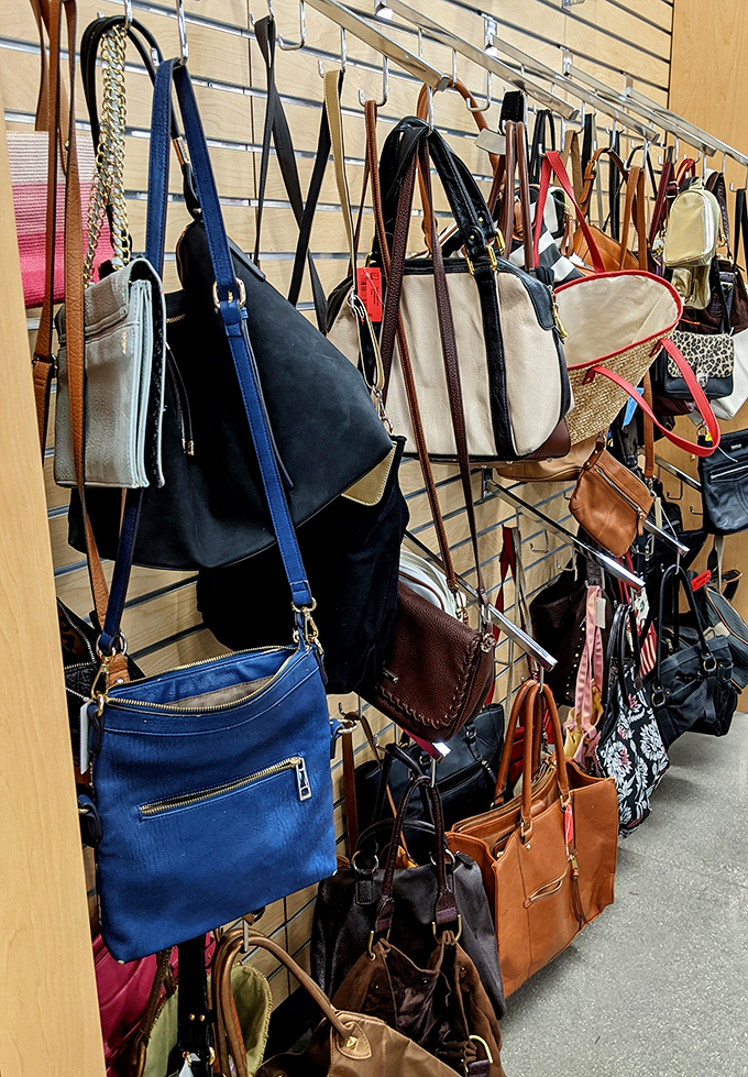 Purses hanging like a leather and canvas art installation, each one carrying stories from its previous life of adventure.