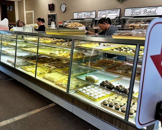 The bakery's display cases stretch like a treasure chest of carbohydrate wonders, each shelf offering a different path to happiness.