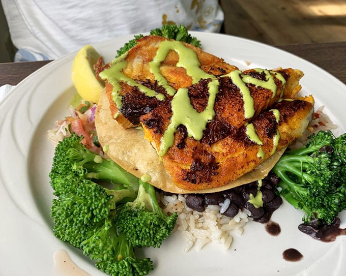 Blackened barramundi perched atop rice and beans, wearing its avocado sauce like a crown&mdash;healthy never looked so indulgent.