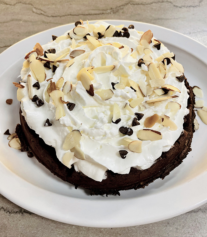 This chocolate-topped Belgian waffle with whipped cream and almonds isn't breakfast&mdash;it's dessert with an alibi. Morning indulgence at its finest.