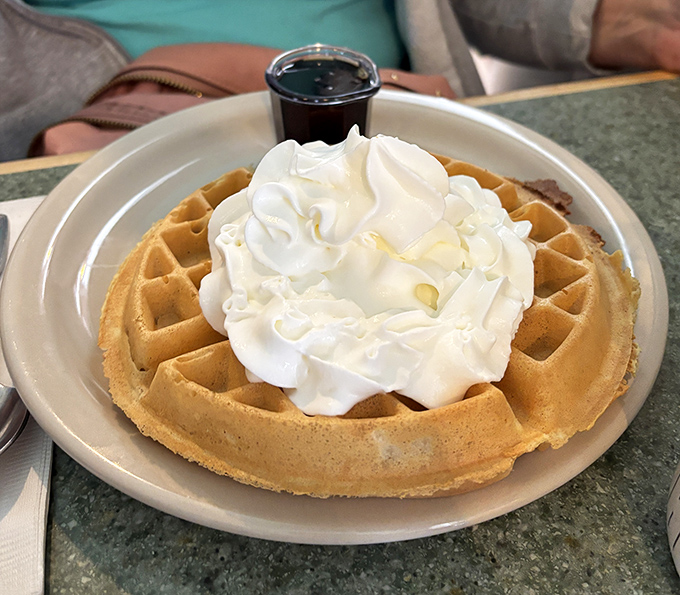 A waffle that's dressed for success with a cloud of whipped cream. Breakfast dessert or dessert breakfast? The line deliciously blurs.
