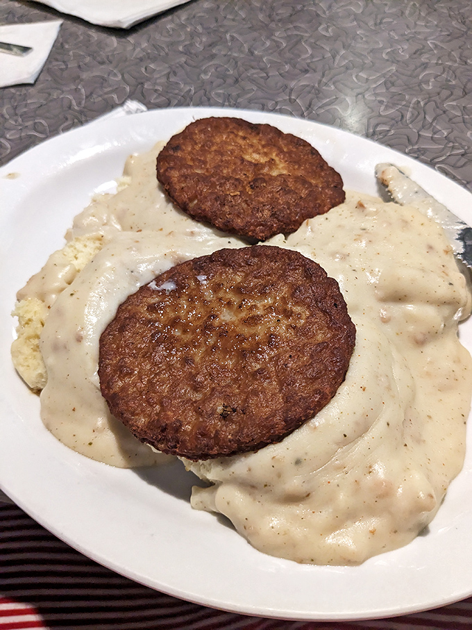 Sausage patties lounging on a bed of country gravy like they're at a five-star resort spa for breakfast meats.
