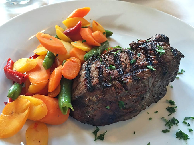 A perfectly cooked steak beside a rainbow of vegetables proves that behind every great piece of meat is a supporting cast that deserves its own standing ovation.