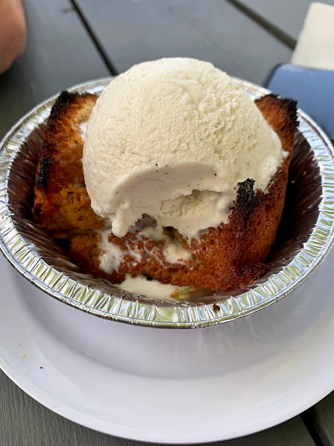 The peach cobbler that launched a thousand road trips, crowned with vanilla ice cream melting into warm, caramelized perfection.