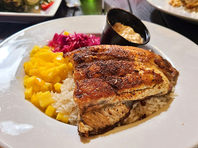 Blackened barramundi that proves sometimes the simplest preparations—a perfect sear, fresh mango, and fluffy rice—create the most memorable meals.