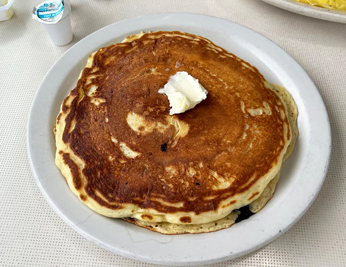The pancake that launched a thousand road trips. Golden, fluffy, and topped with a dollop of butter melting like a summer sunset.