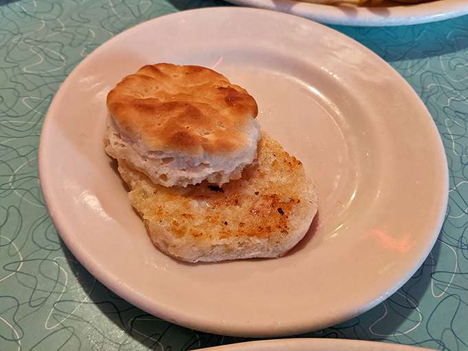 A perfectly toasted biscuit sitting proudly on its plate, ready to be the supporting actor in your breakfast drama. 