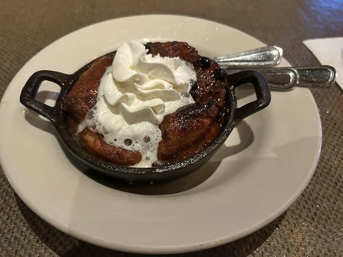 Bubbling bread pudding served in a cast-iron skillet with melting cream &ndash; comfort food elevated to an art form.