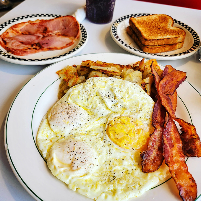 The breakfast trinity &ndash; perfectly fried eggs with that sunshine yellow center, crispy bacon, and home fries that somehow manage to be both crispy and tender.