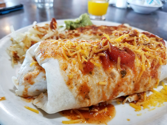 Breakfast burrito perfection: cheese melting over a flour tortilla stuffed with morning goodness, ready to kickstart your day with southwestern flair.