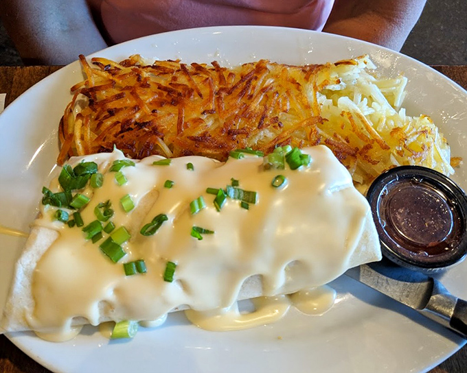 This breakfast burrito, blanketed in cheese sauce and flanked by crispy hashbrowns, isn't messing around with portion size.