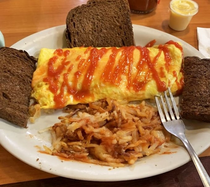 An omelet drizzled with hot sauce atop crispy hash browns&mdash;proof that breakfast is the most important art form of the day.