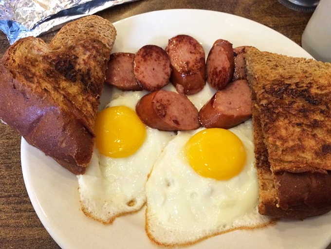 The holy trinity of breakfast: perfectly sunny eggs, toast with actual butter, and sausage with the kind of sear that makes you want to applaud.