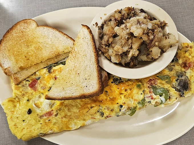 Breakfast done right: a veggie-packed omelet, crispy toast, and those legendary home fries that somehow taste like childhood memories.