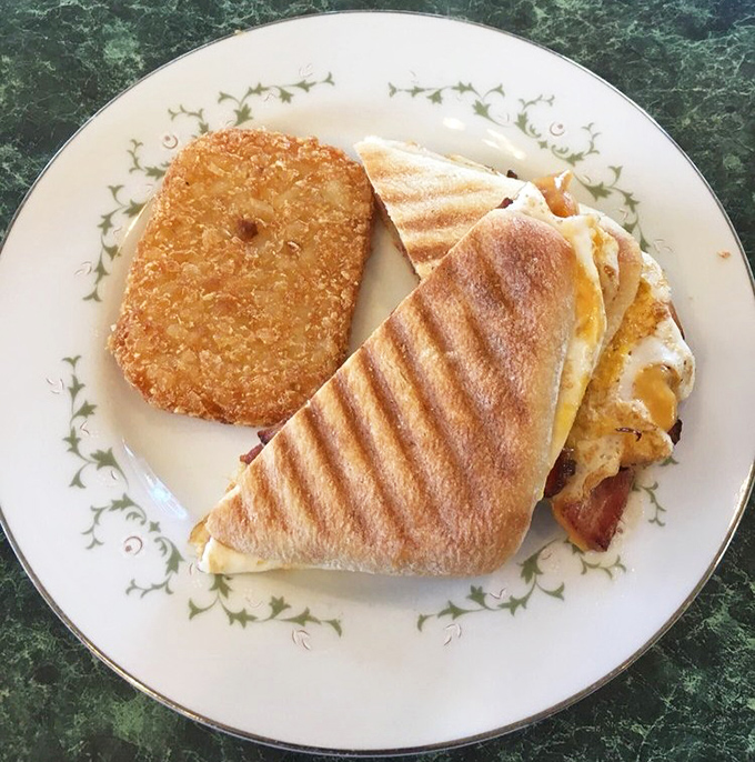 The breakfast panini arrives with perfect grill marks and a hash brown sidekick. This is the breakfast power couple your morning deserves.
