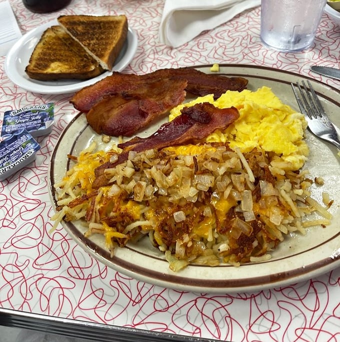 The breakfast trinity&mdash;crispy hashbrowns, fluffy eggs, and bacon cooked to perfection&mdash;proof that some relationships are meant to last forever.