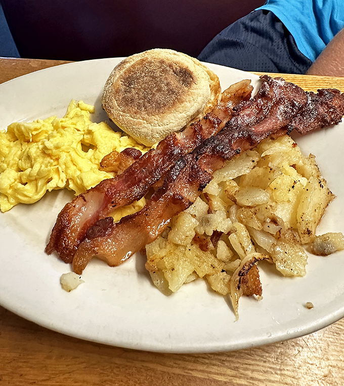 The breakfast platter that launched a thousand beach days: crispy bacon, scrambled eggs, and home fries that deserve their own fan club.
