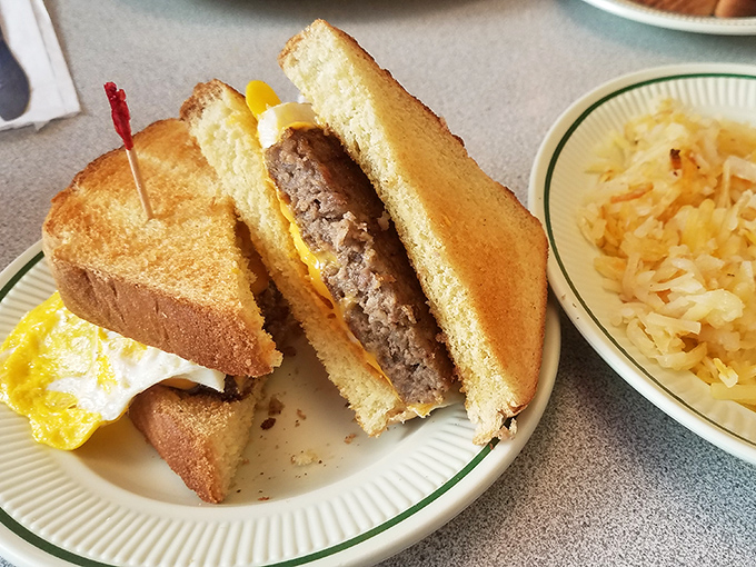 The breakfast sandwich trinity: golden toast, farm-fresh egg, and savory sausage, with a side of hash browns that deserve their own fan club.