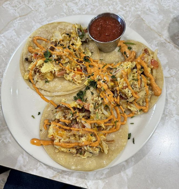 Breakfast tacos that bring a fiesta to your morning. That drizzle of sauce isn't just decoration—it's liquid sunshine.