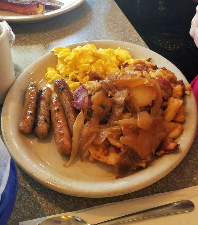 Breakfast perfection: golden sausage links, scrambled eggs that look like sunshine, and home fries with that ideal crisp-to-tender ratio.
