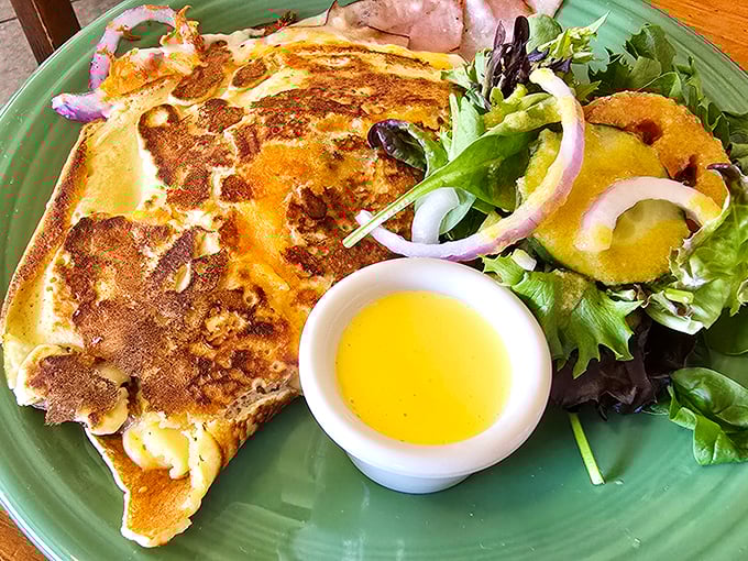 This fluffy creation looks like breakfast won the lottery. Fresh greens and vibrant red onions add color to a plate that's basically morning sunshine made edible.
