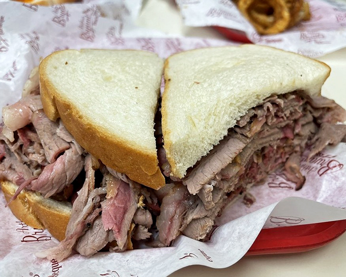 The brisket sandwich: where two humble slices of white bread valiantly attempt to contain a mountain of smoky perfection.