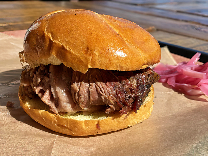 The brisket sandwich—so tender it practically surrenders at first bite. This isn't just lunch; it's a religious experience with pickled onions.