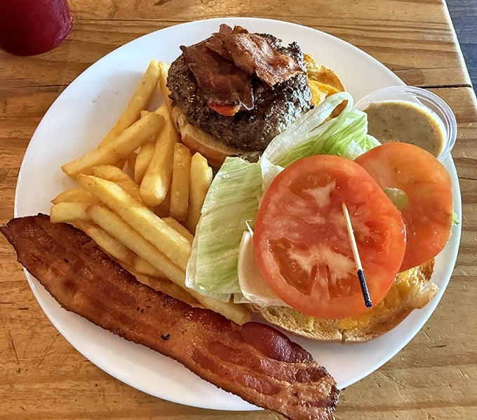 This isn't just a burger &ndash; it's architecture with purpose: towering bacon, fresh vegetables, and a brioche bun that somehow defies gravity.