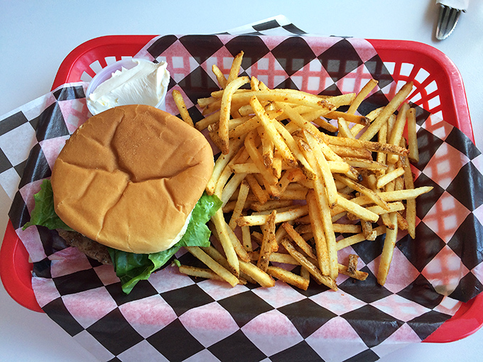 A classic burger and fries served on a red basket with checkered paper—proof that happiness doesn't need fancy packaging.