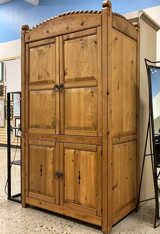 This solid wood armoire stands like a dignified elder statesman among furniture, waiting for someone to recognize its quality craftsmanship and potential.