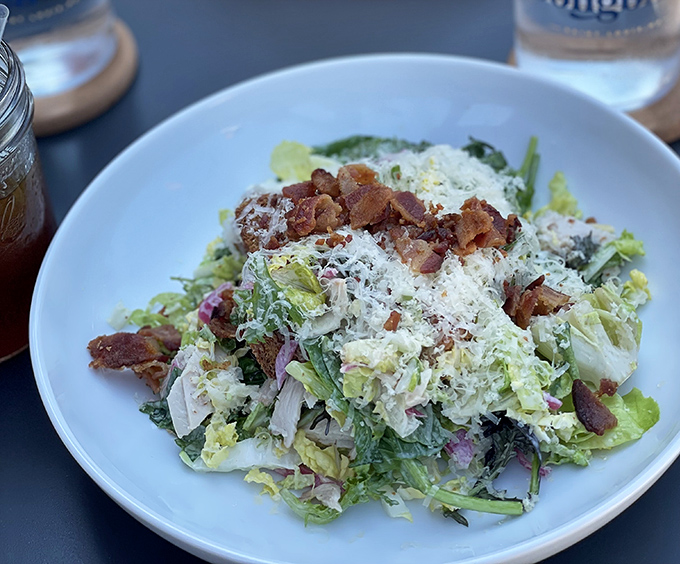 Even the salads deserve attention—crisp greens, bacon bits, and freshly grated cheese create a symphony of textures that would make any lunch hour better.