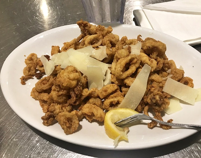 Crispy calamari with shaved parmesan&mdash;proof that sometimes the simplest preparations create the most memorable bites. The lemon wedge isn't optional, folks.