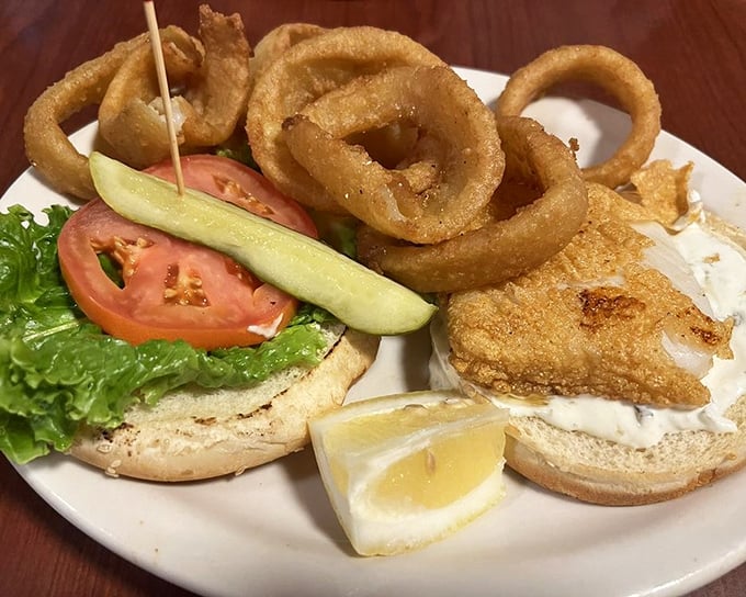The seafood sandwich comes dressed for success with crisp lettuce, ripe tomato, and those golden onion rings that somehow make waiting for your entr&eacute;e even harder.