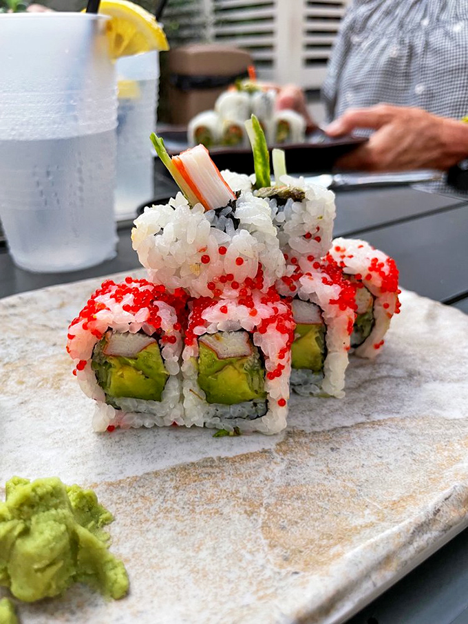 Sushi rolls wearing their finest red tobiko "accessories." A California roll that's had a glamorous Florida makeover, complete with wasabi sidekick.