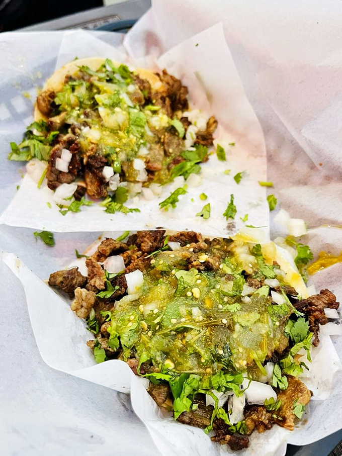Carne asada tacos dressed with cilantro, onion, and salsa verde&mdash;proof that sometimes the simplest combinations create the most profound flavors.