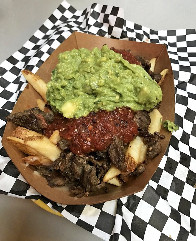Carne asada fries: where comfort food meets art installation. That guacamole dollop isn't just a topping&mdash;it's the emerald crown jewel.