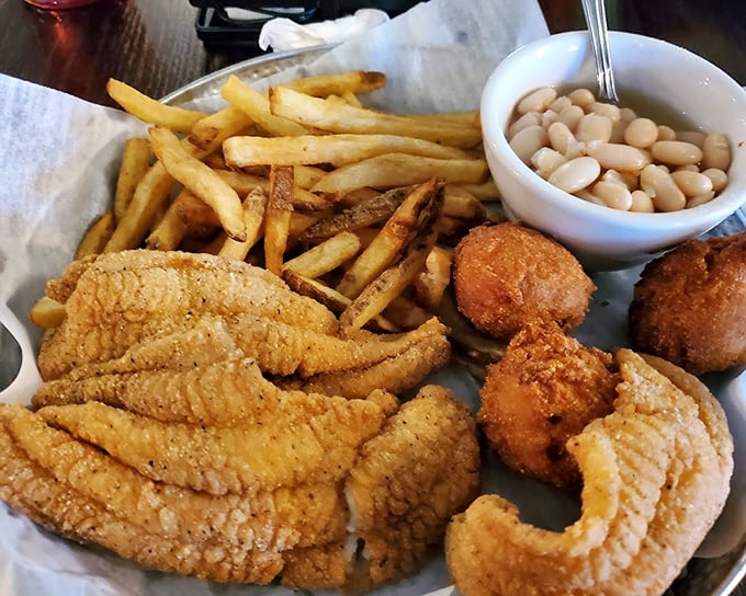 A plate that celebrates the marriage of land and sea&mdash;catfish strips, white beans, and hush puppies creating the comfort food trifecta of champions. 