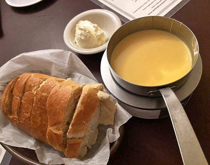 The cheese fondue arrives like liquid gold, making that crusty sourdough bread feel like it won the lottery of perfect pairings.