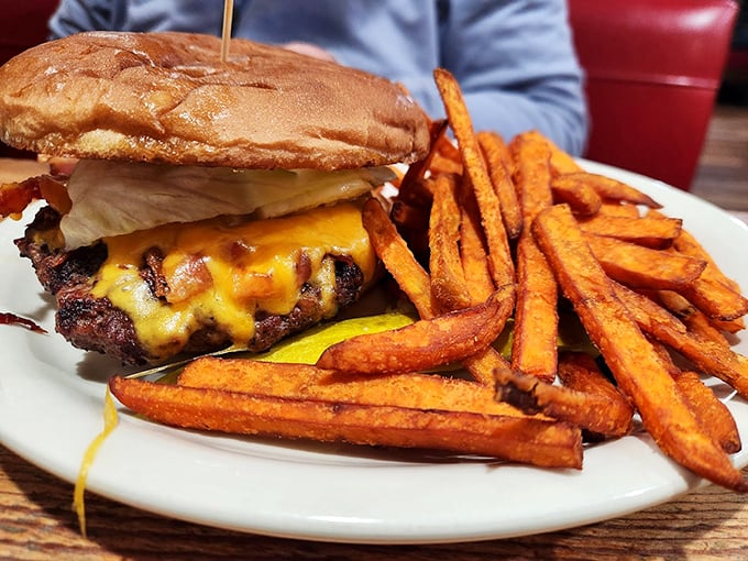 This isn't just a burger&mdash;it's architecture. The melted cheese cascading down the sides, those sweet potato fries standing at attention&mdash;pure edible art.