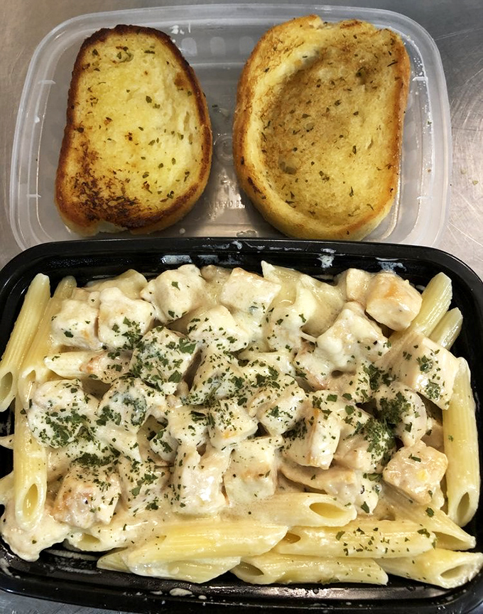 Garlic bread standing guard over creamy chicken alfredo pasta&mdash;proof that soul food cafes contain multitudes and defy simple categorization.