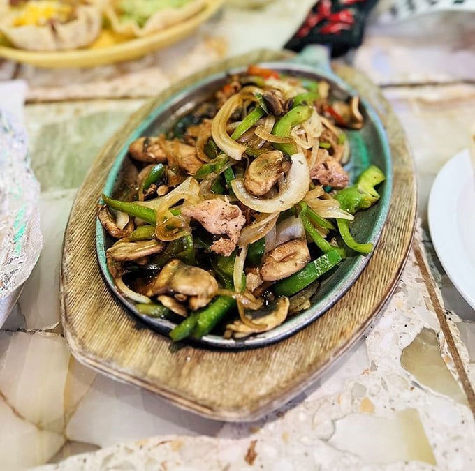 Sizzling fajitas that announce their arrival before you see them, a symphony of caramelized onions and peppers playing backup to tender chicken.