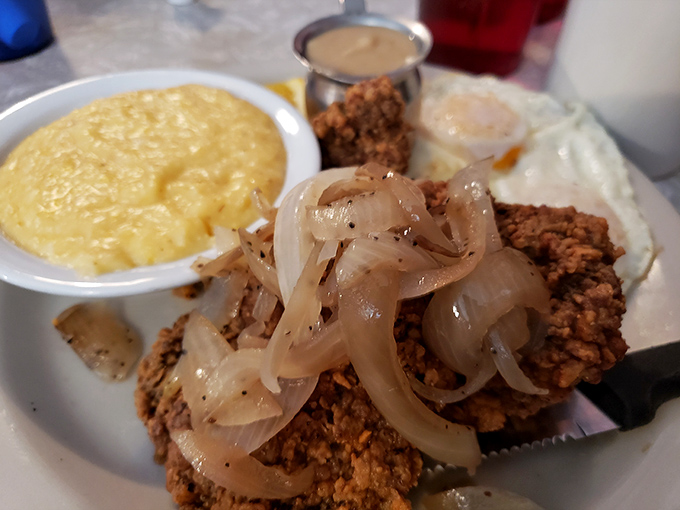 Country fried steak with caramelized onions and gravy alongside scrambled eggs and grits&mdash;the breakfast equivalent of a warm Southern hug.