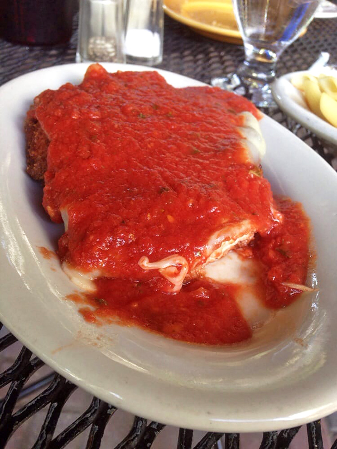 The star of the show &ndash; Chicken Parmesan with a golden crust that somehow stays crisp beneath that glorious red sea of homemade marinara and melted cheese.