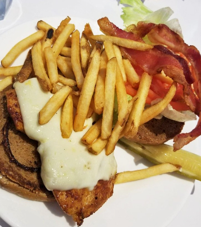 This isn't just a chicken sandwich; it's architecture. The melted cheese cascading over the edge like a dairy waterfall deserves its own Frank Lloyd Wright award.