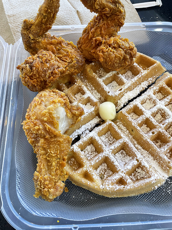The holy grail&mdash;crispy golden chicken perched atop a powdered waffle with a pat of butter melting into those perfect squares.
