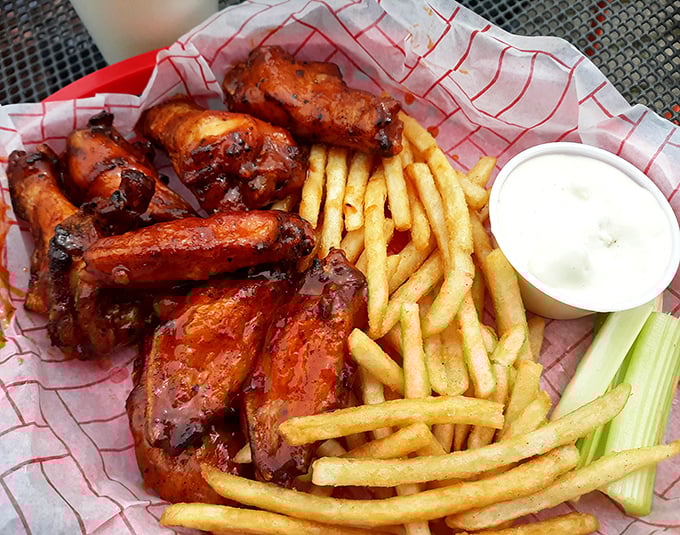 Chicken wings glazed to mahogany perfection alongside golden fries&mdash;proof that sometimes the simplest pleasures are the most profound.