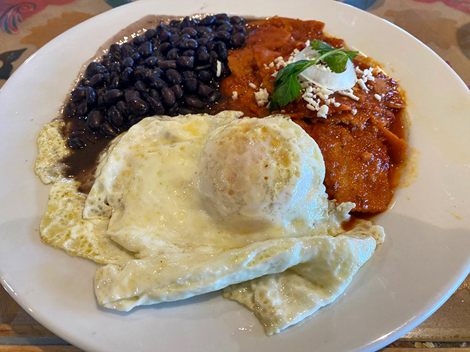 Breakfast nirvana achieved: eggs nestled atop crispy tortillas, swimming in sauce that would make getting out of bed at 5 AM completely justifiable.